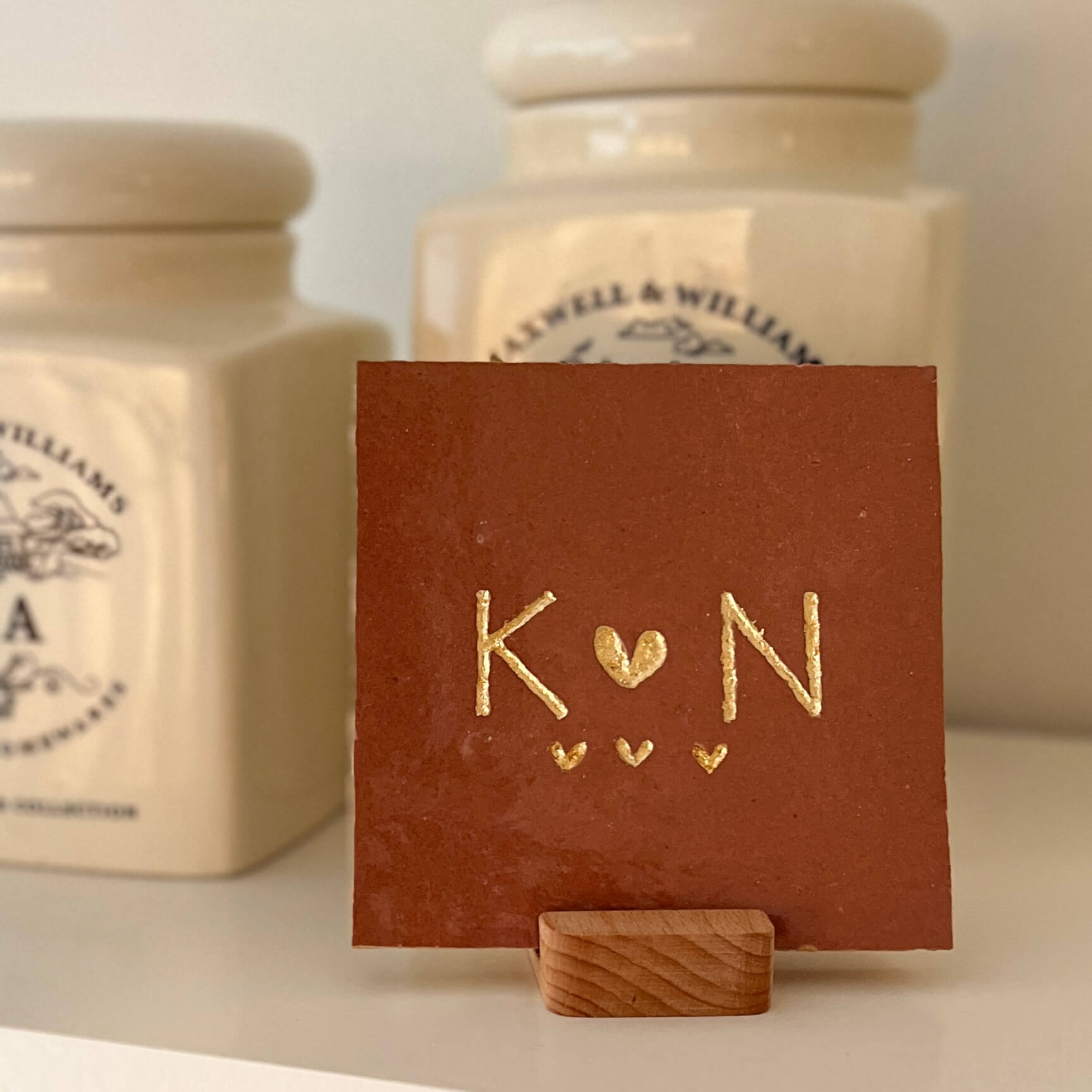 Tegeltje met een letter een hartje een letter en drie kleine hartjes ...